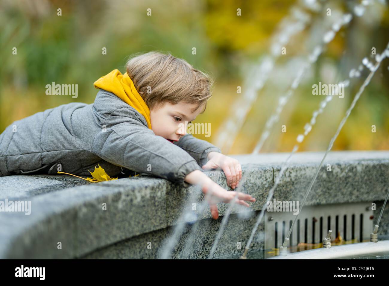 Cute little boy playing outdoors on sunny autumn day. Child exploring ...