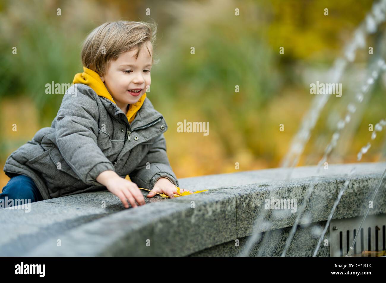 Cute little boy playing outdoors on sunny autumn day. Child exploring ...
