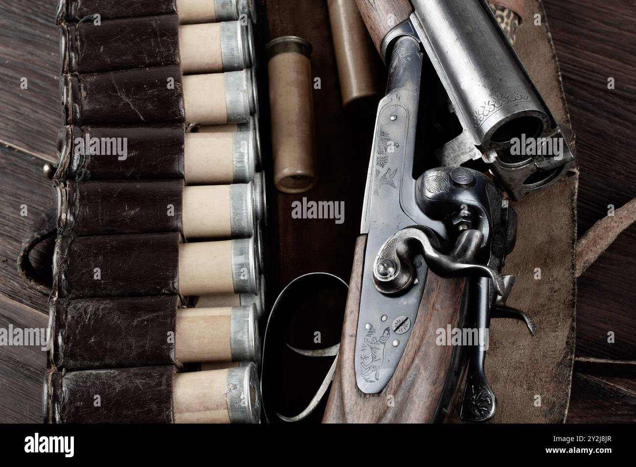 double barreled side shotgun with cartridges in bandolier on wooden ...