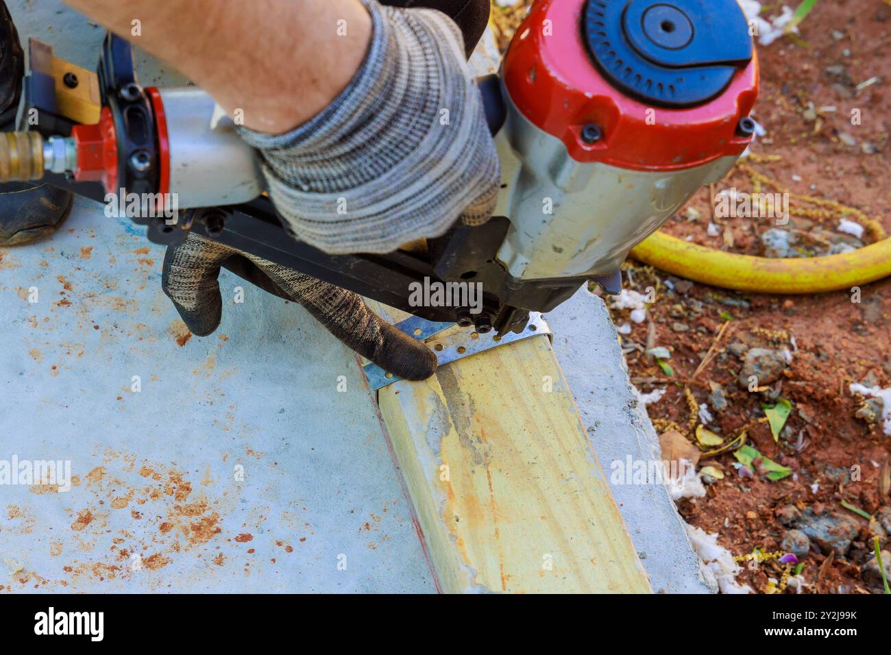 Pneumatic air hammer is used to nail wooden beams to concrete during ...