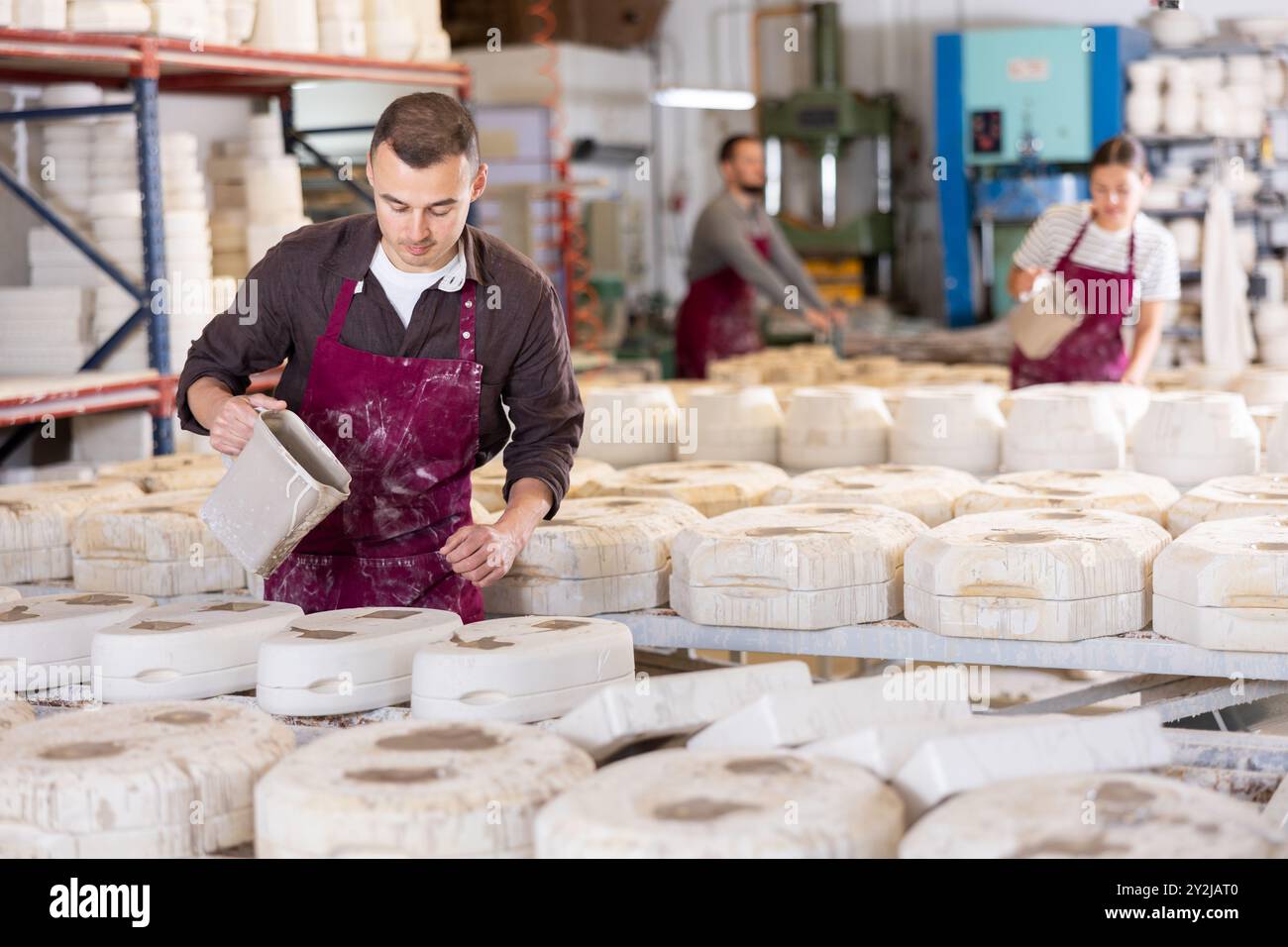 Young man pouring clay into mold Stock Photo - Alamy