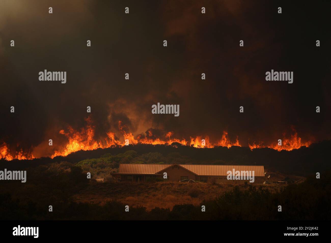 The Airport Fire crests over a structure Tuesday, Sept. 10, 2024, in El ...