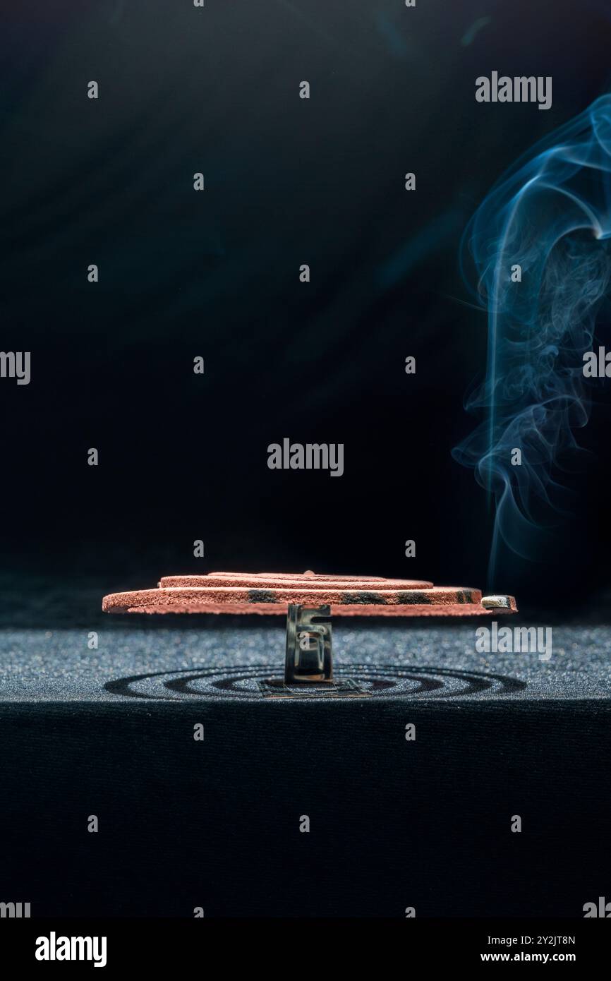 A mosquito coil with smoke coming out of it. The object is circular and ...