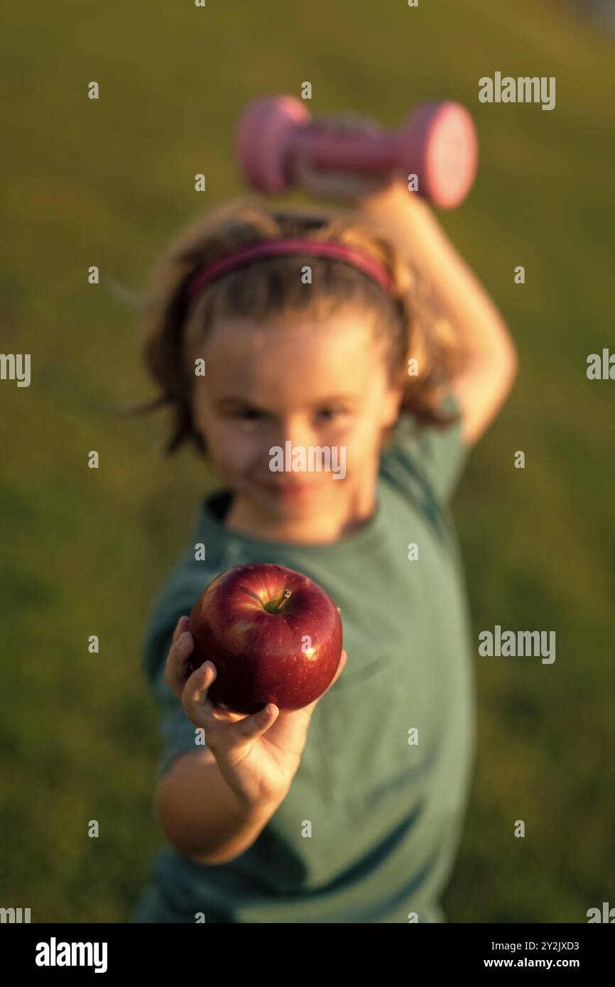 Healthy sporty child with apple and dumbbell outdoor in park. Kids ...