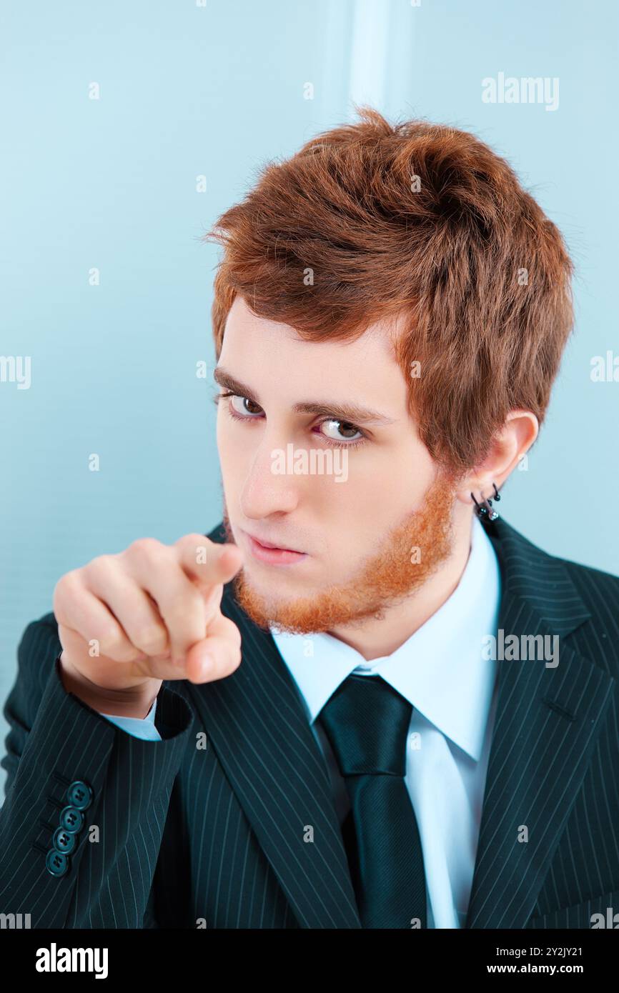 Stern looking businessman pointing his finger directly at the viewer ...