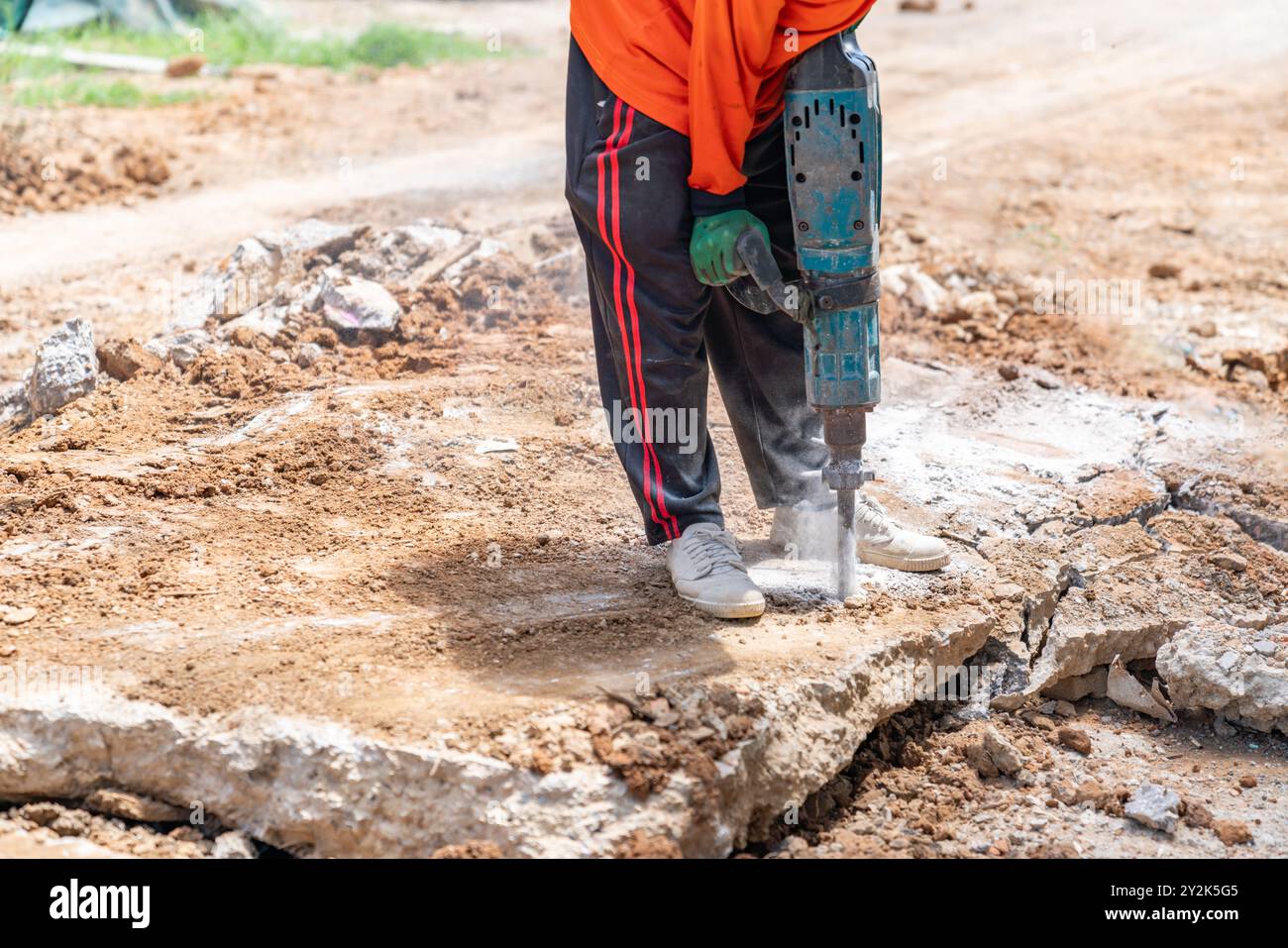Worker breaking concrete with jackhammer in construction site Stock ...