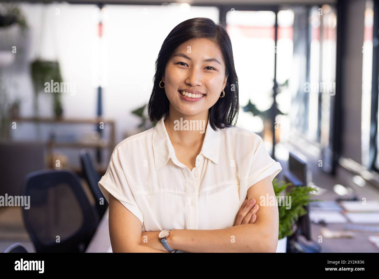 Standing in modern office, confident asian woman with arms crossed ...