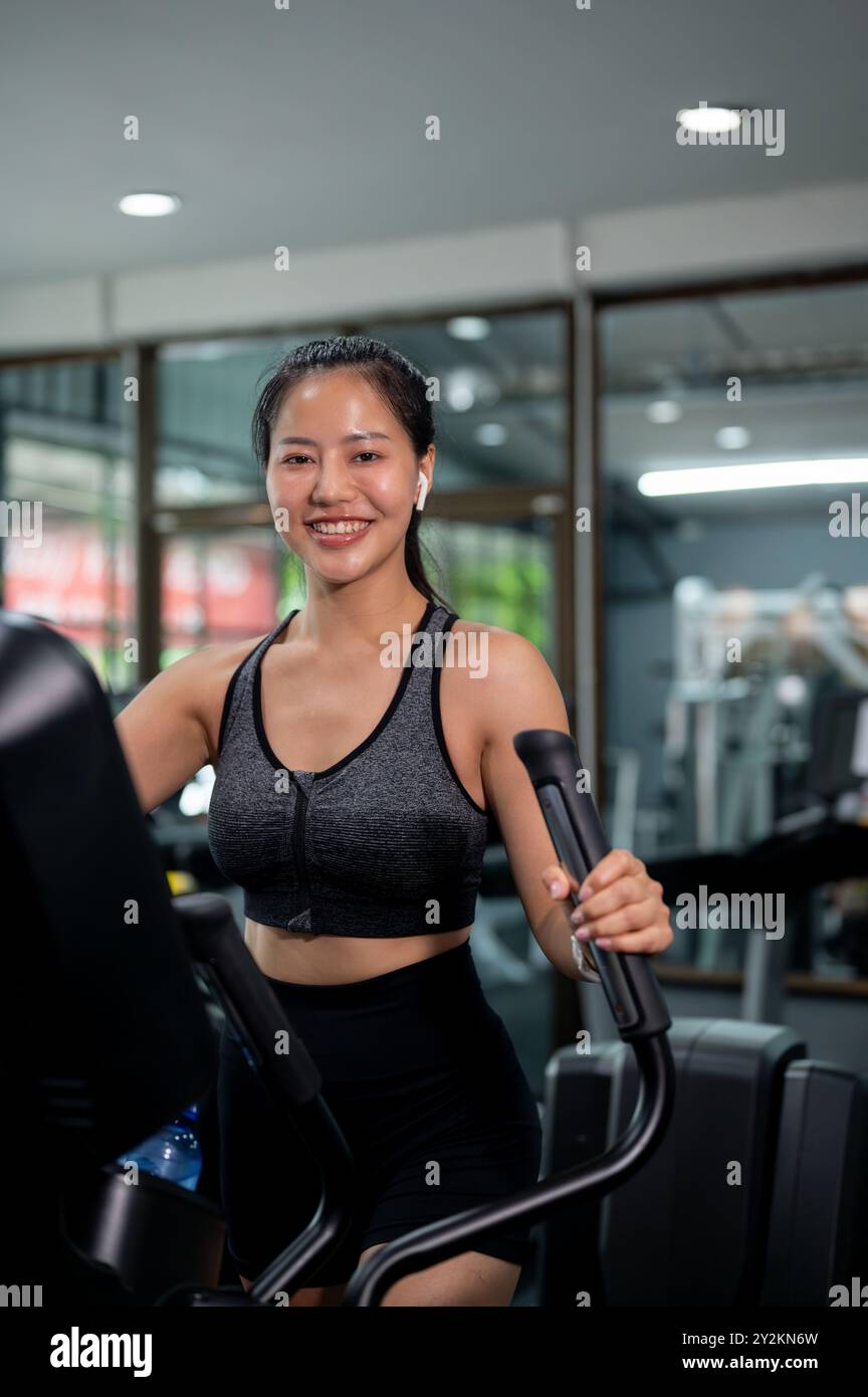 A beautiful, sporty Asian woman in sportswear is running on an ...