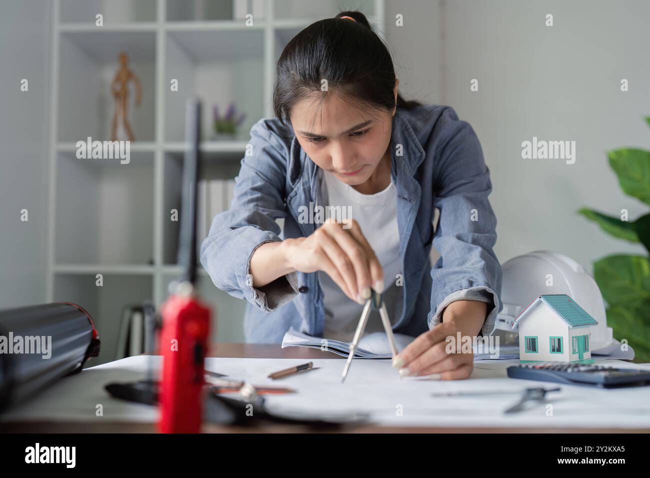 Engineer using compass for architectural drafting in office Stock Photo ...
