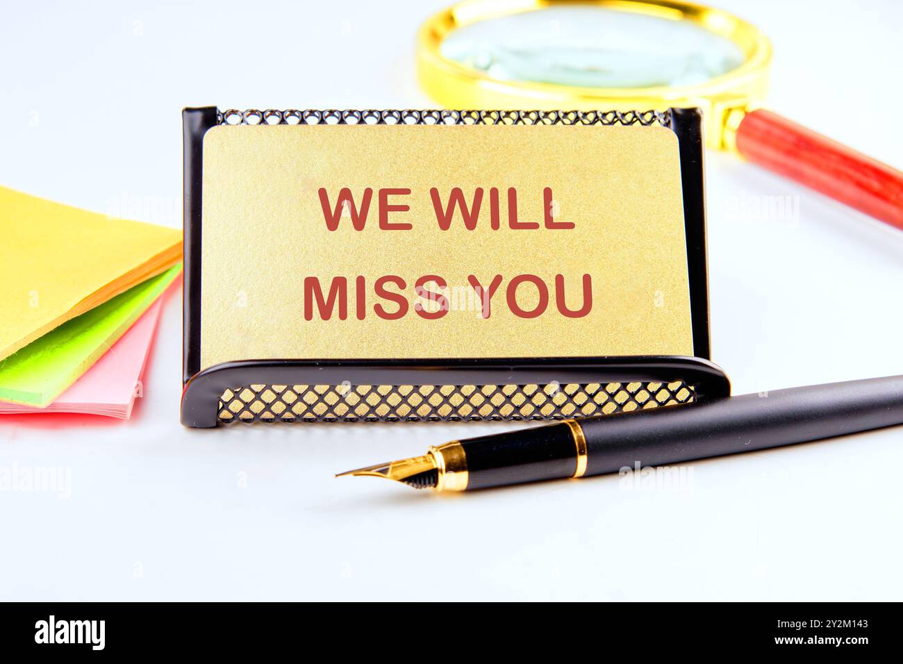 WE WILL MISS YOU written on a gold card on a stand with business ...
