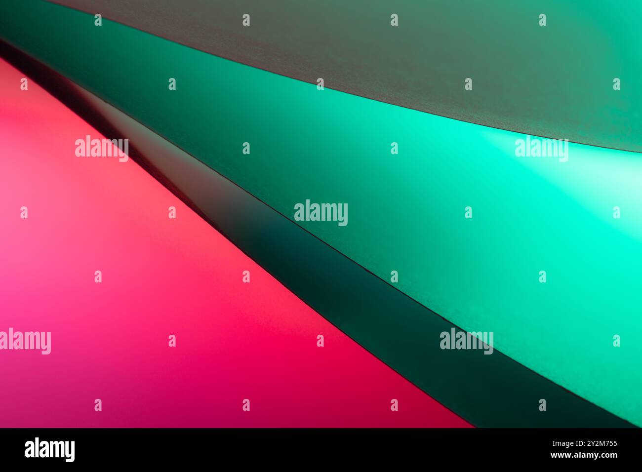 Curved shapes in vibrant green, red and gray blend together ...