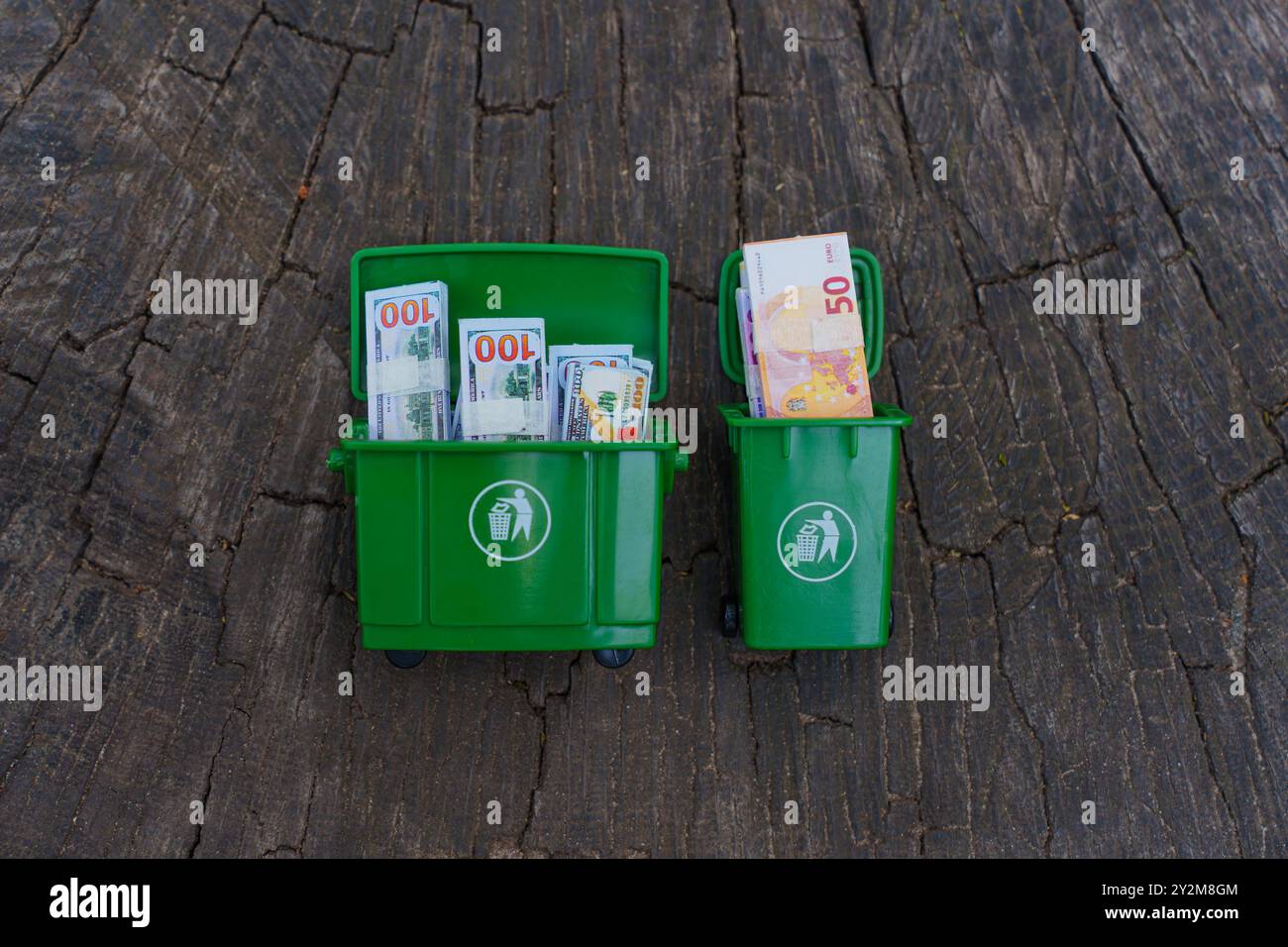 Trash bins overflowing with cash representing wasted money and poor ...