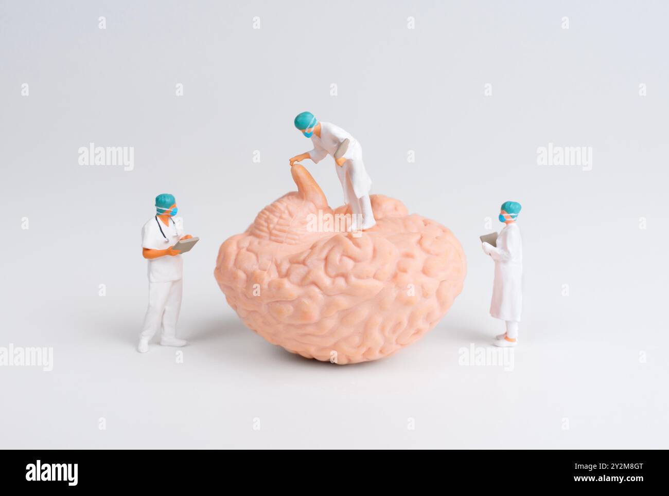 Miniature surgeon figurines analyzing and operating on a realistic ...