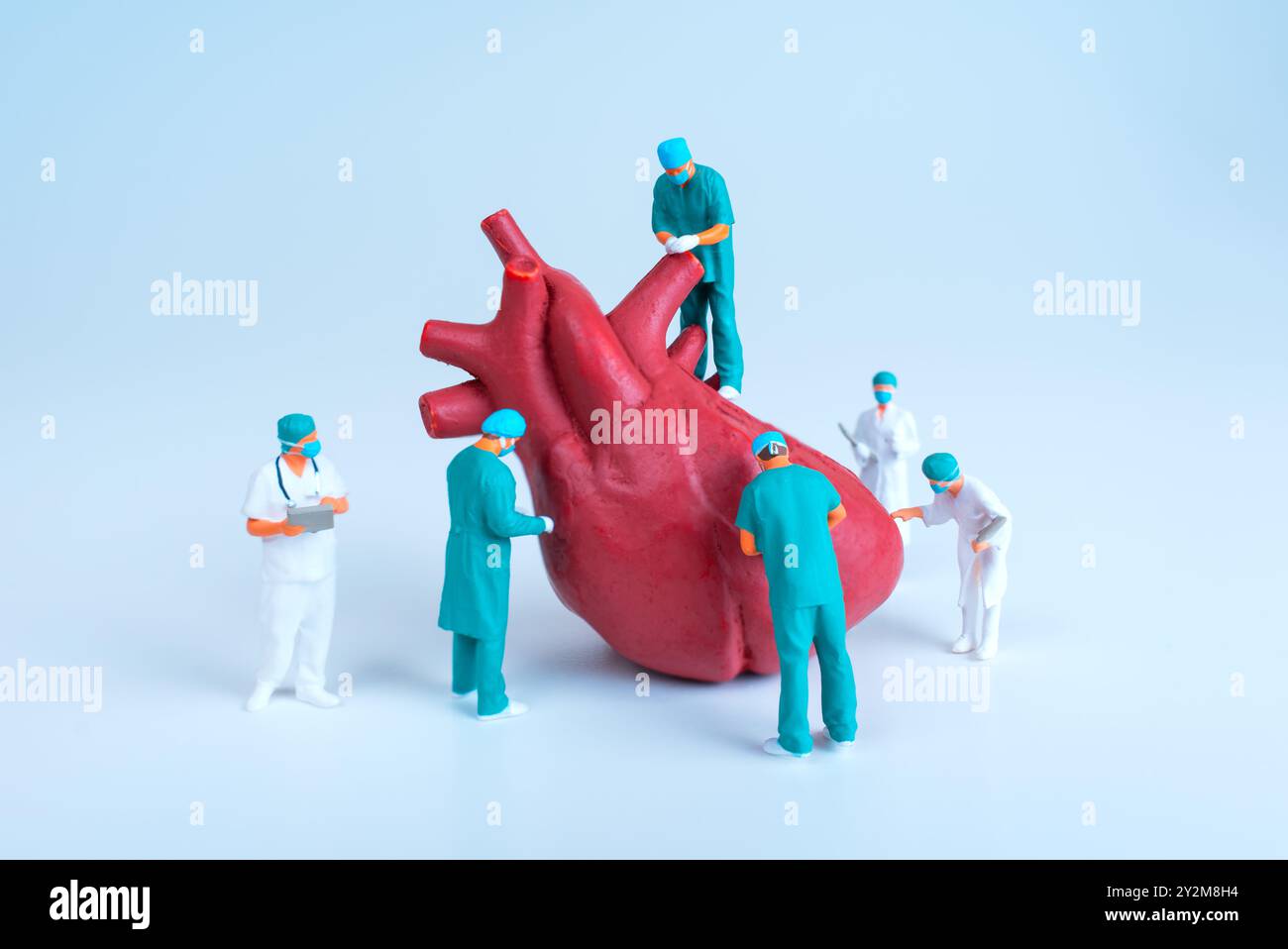 Dynamic scene of miniature surgeons collaborating on a large heart ...