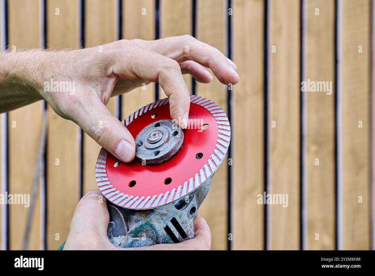 Worker mounts diamond circular saw for cutting stone and concrete on ...