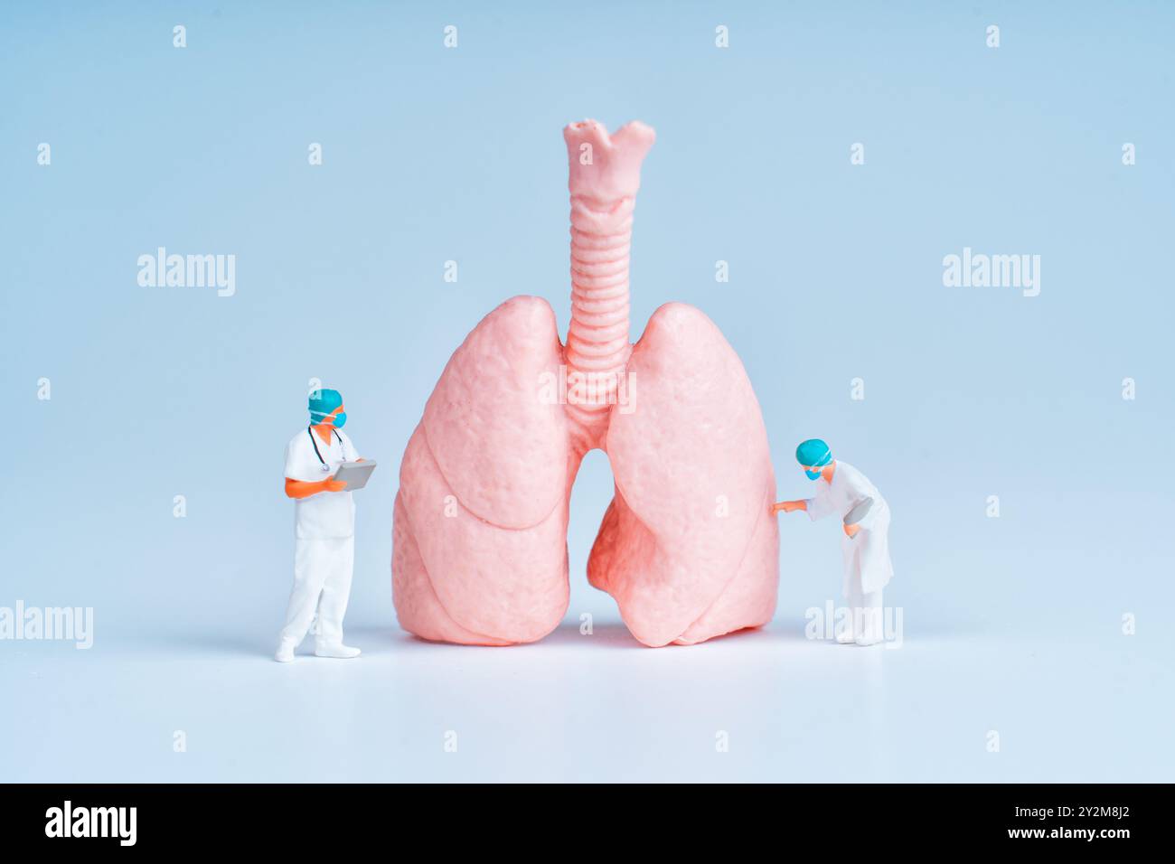 Miniature doctors examining a model of human lungs, highlighting ...