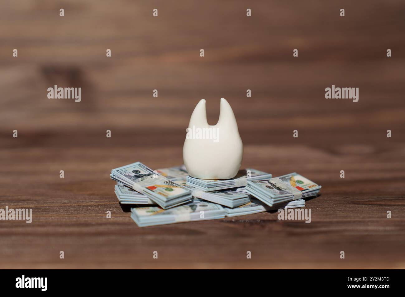 Realistic dental model placed on a bed of money, representing dental ...