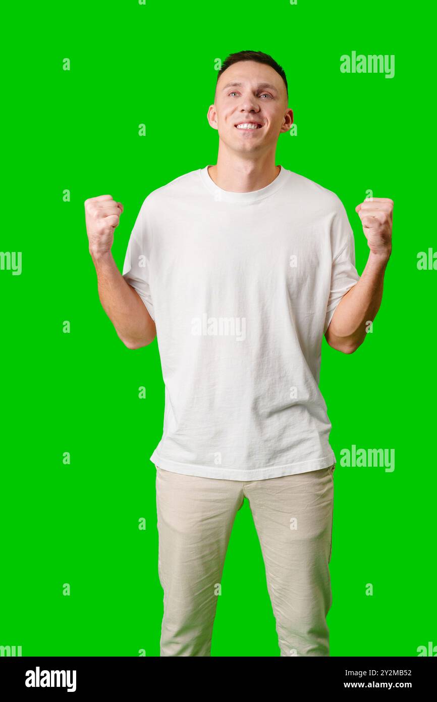 Young Man Celebrates Success With Energetic Pose Against Vibrant Green ...