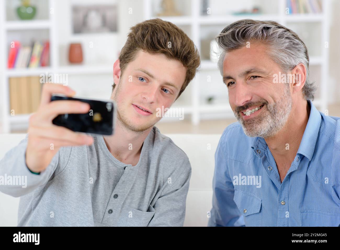 Adolescent boy talking photo of himself with his father Stock Photo - Alamy