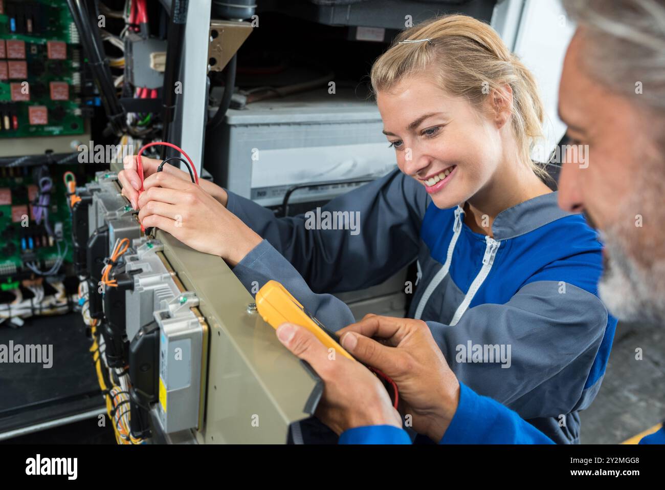 female technician with digital meter measuring voltage Stock Photo - Alamy