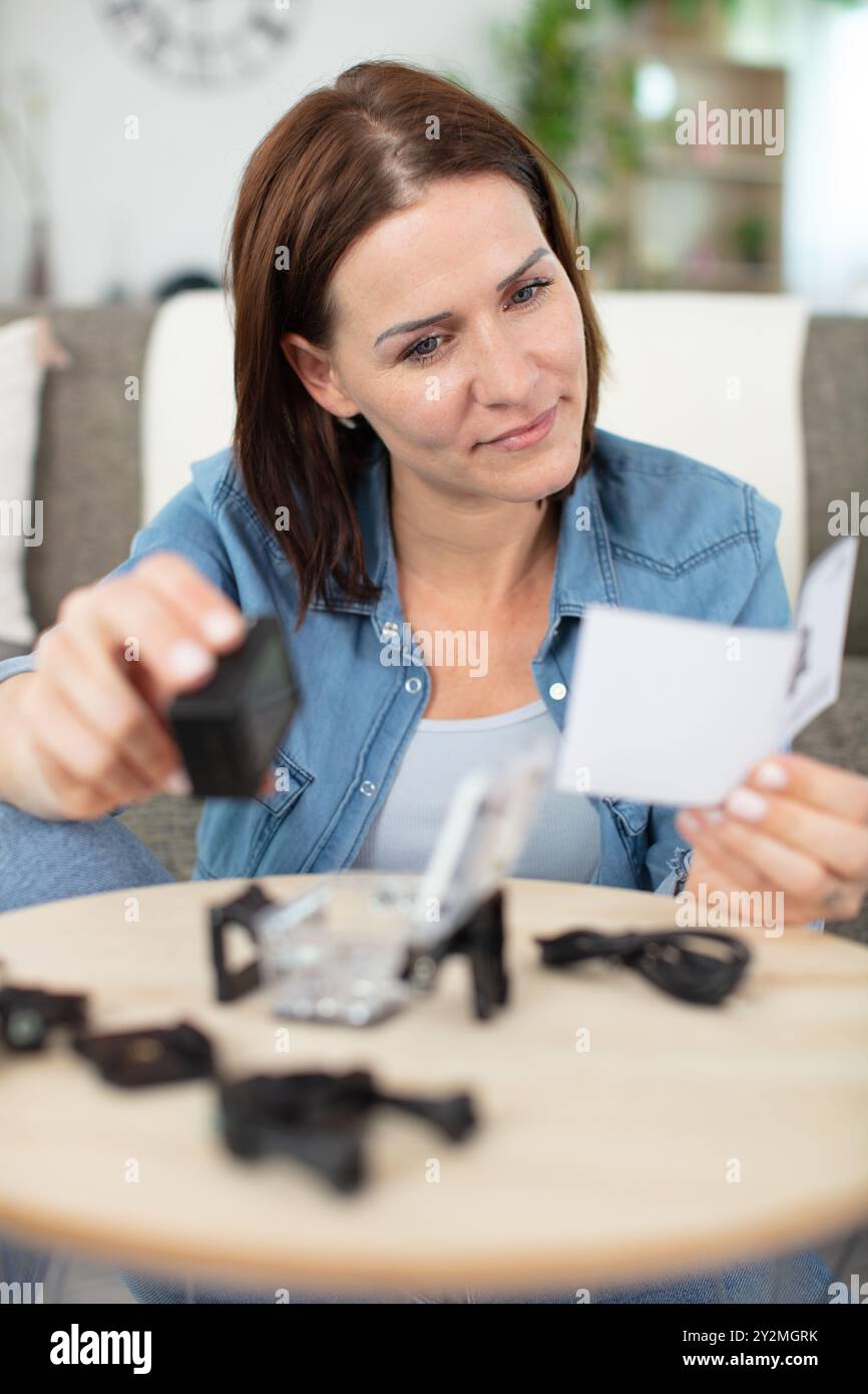 woman following instructions to assemble an action camera Stock Photo ...