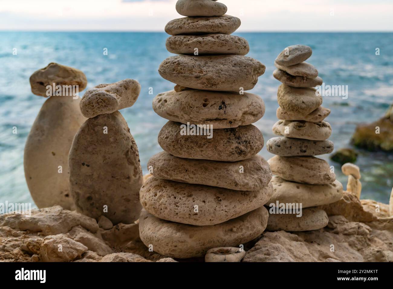 Stone Cairns Beach Ocean - Three stone cairns stacked on a sandy beach ...