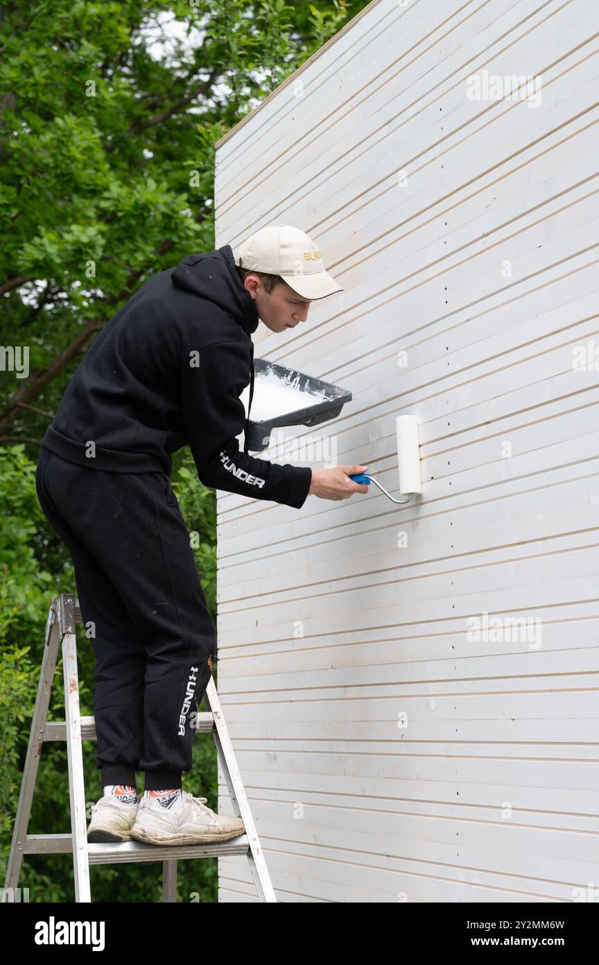 Ivano-Frankivsk, Ukraine, May 11, 2024: a boy paints the wall of a ...