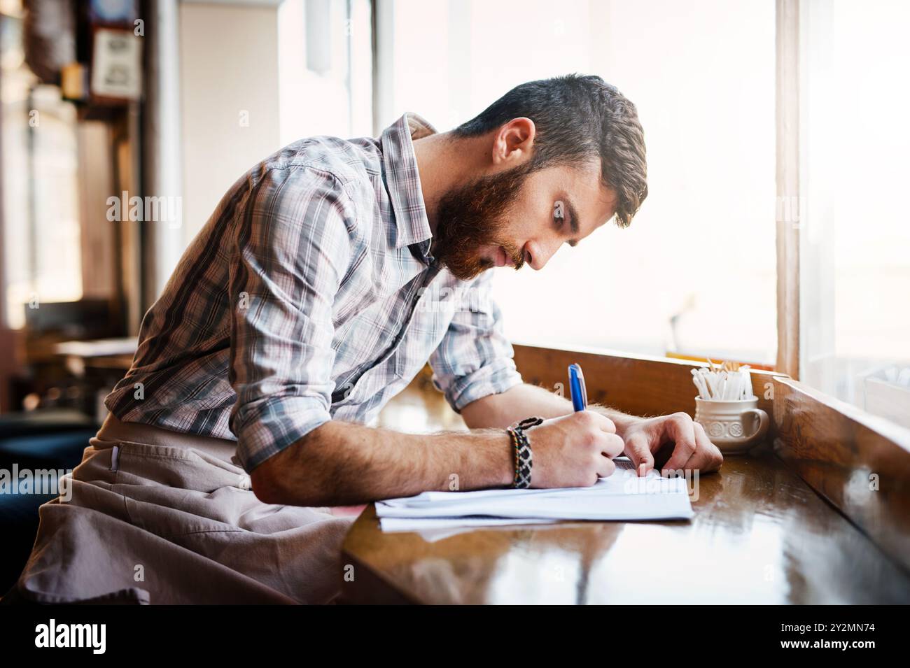 Coffee shop, writing and man with paperwork for inventory, menu items ...