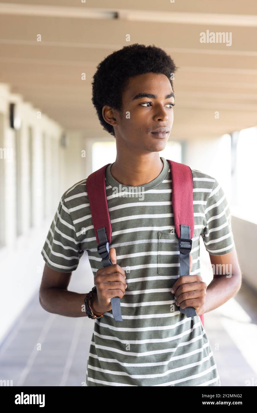 Teenage african american teenage boy with backpack standing in school ...