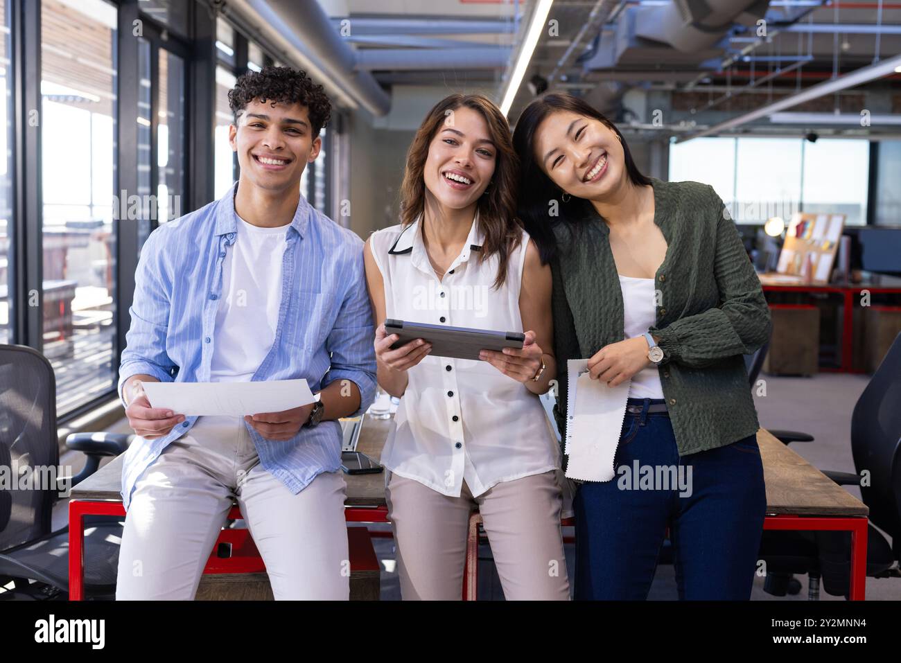 Smiling diverse colleagues holding documents and tablet, collaborating ...