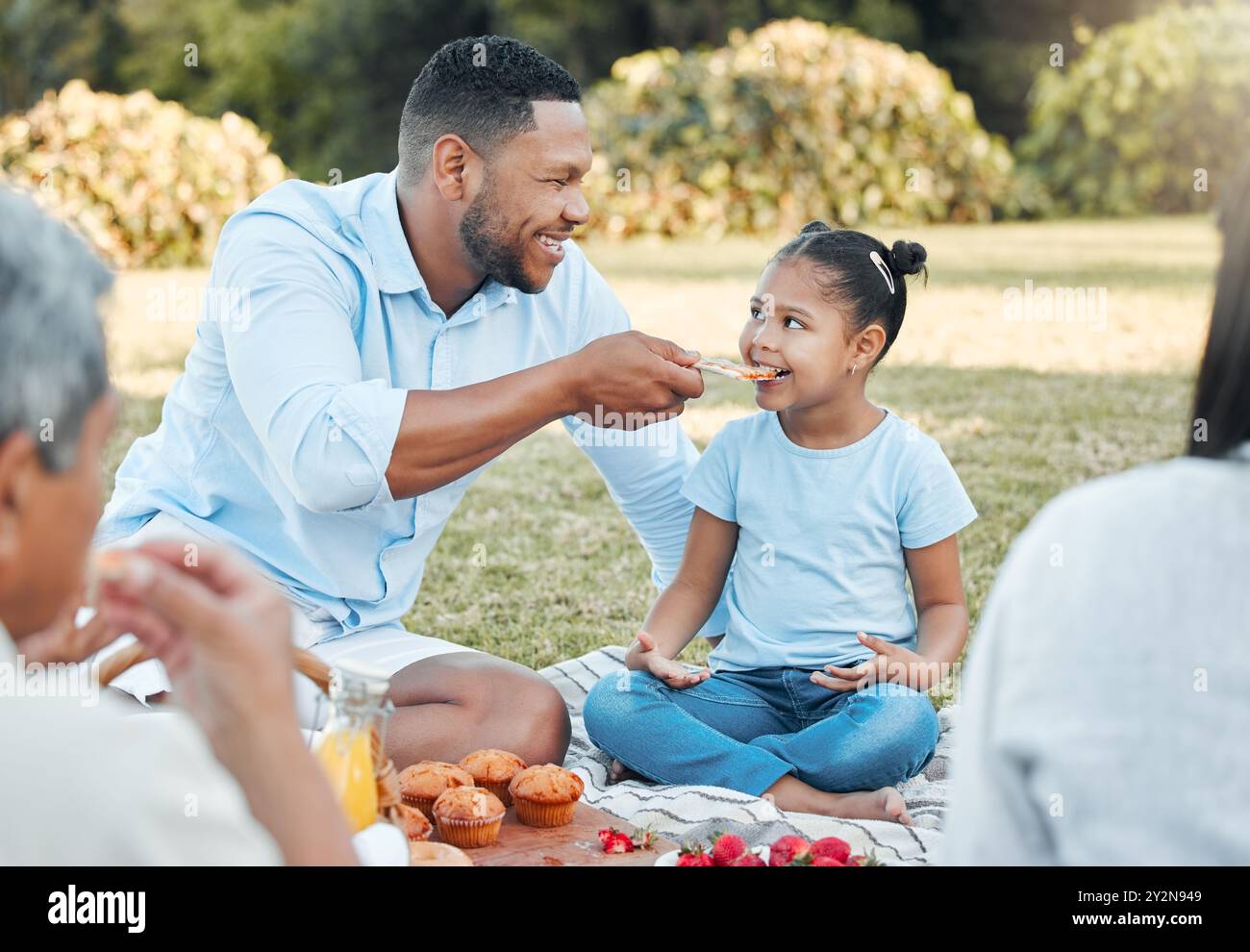Feeding, family picnic and father with daughter in park for food ...
