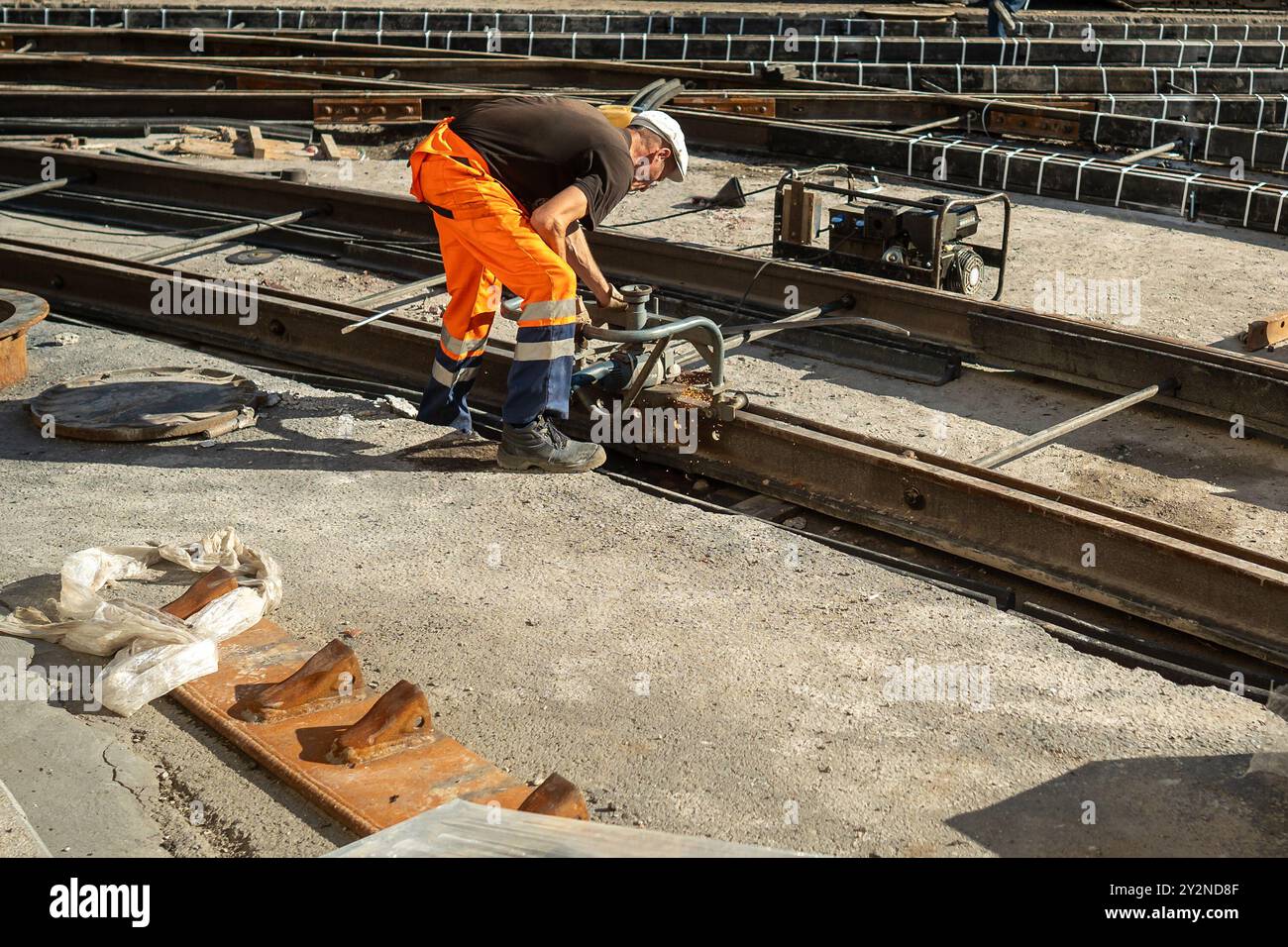 Worker polish rail joint with small grinding machine after welding ...