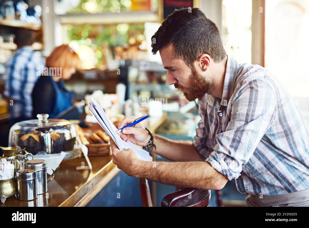 Coffee shop, writing and man with documents for menu items, stock and ...