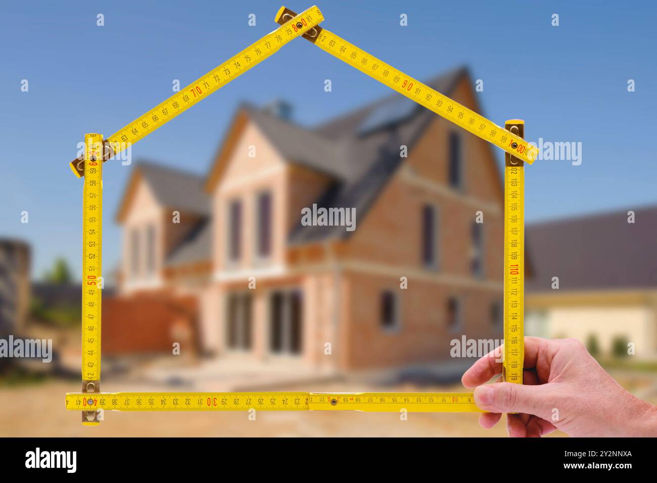 Neubau mit Meterstab Ein Meterstab ist gefaltet in Form von einem Haus ...