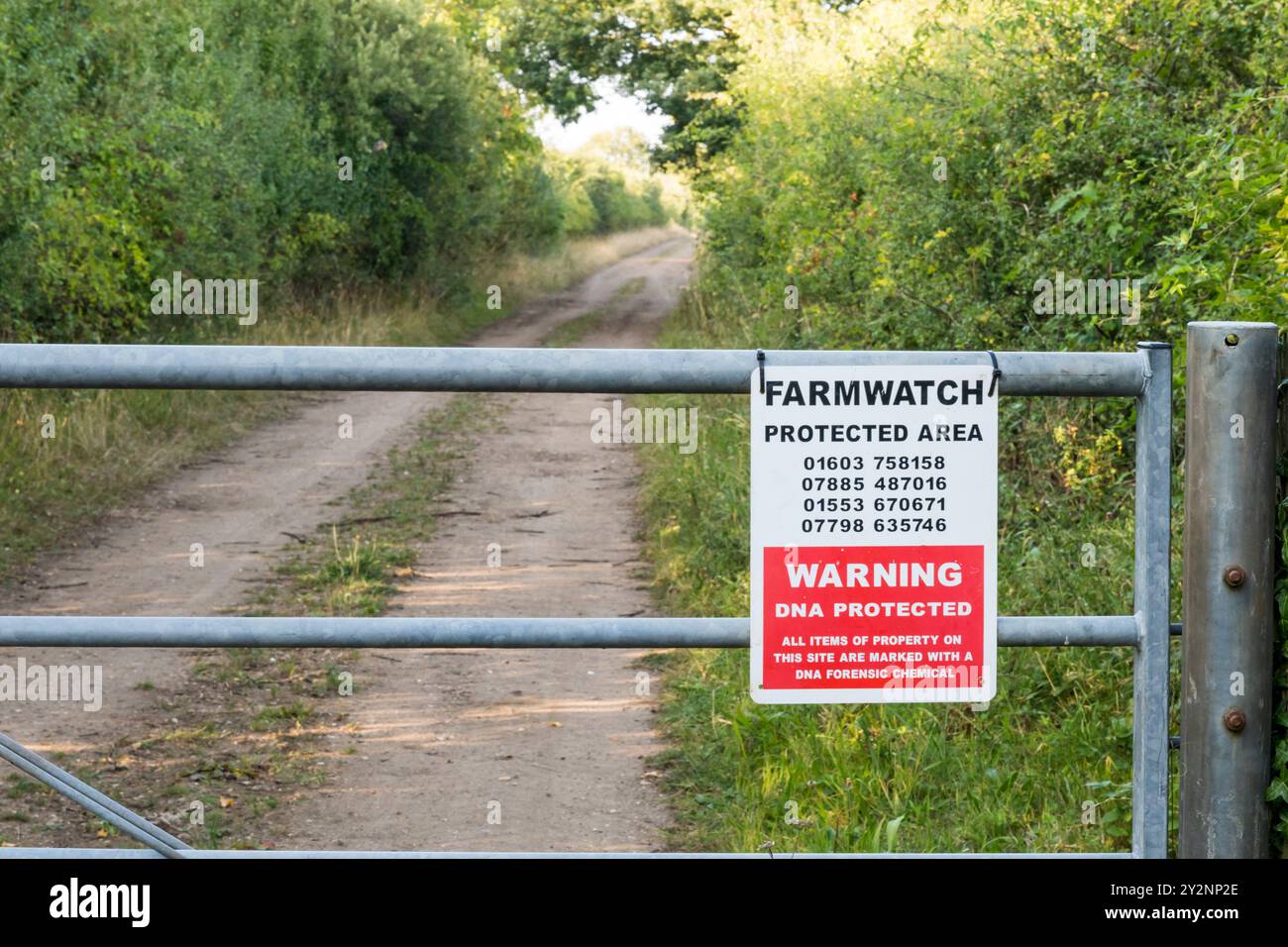 A Farmwatch Protected Area sign on a gate across a farm lane in Norfolk ...