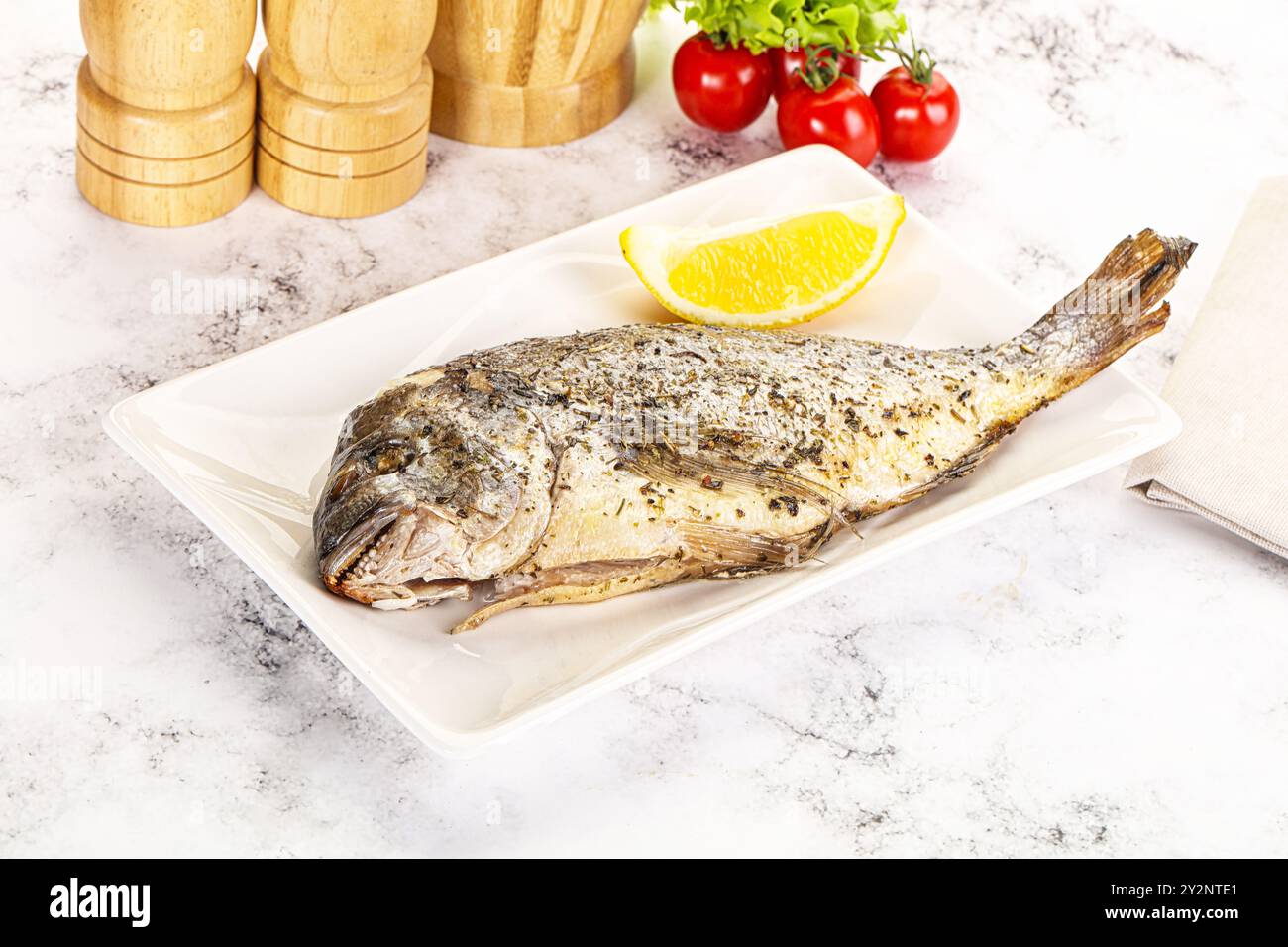 Baked Dorado fish served lemon slice Stock Photo - Alamy