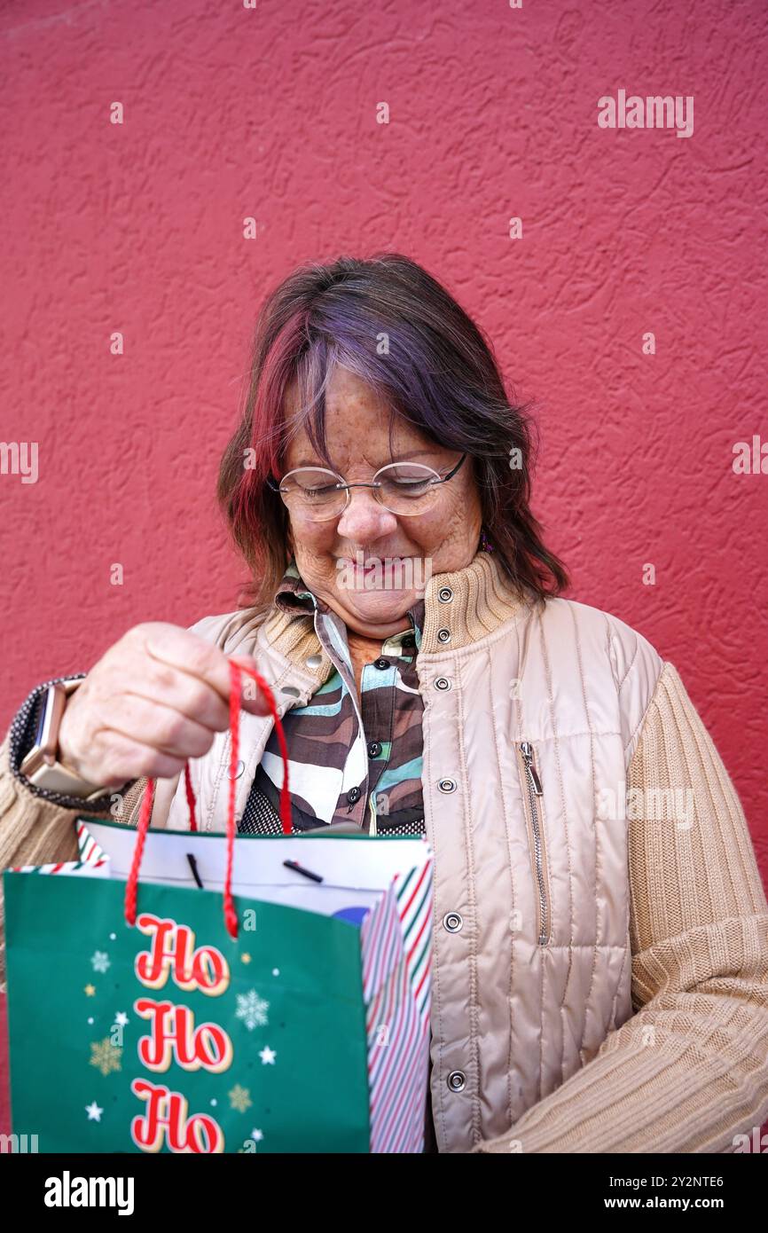 old woman christmas shopping with red background. Spanish tradition ...