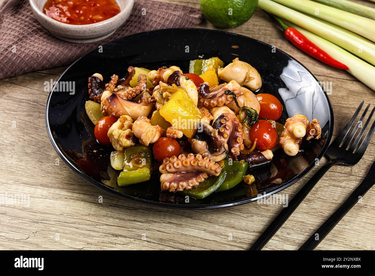 Roasted octopus with vegetables, spices and oil Stock Photo - Alamy