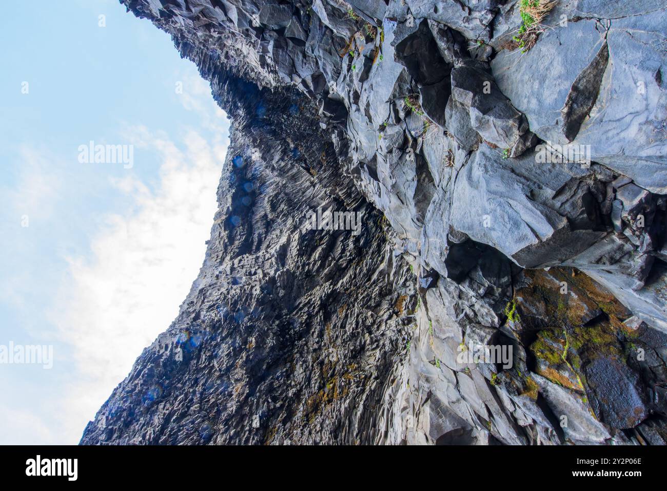 Towering basalt columns create a dramatic backdrop at Reynisfjara, Iceland. The rugged cliffs ...