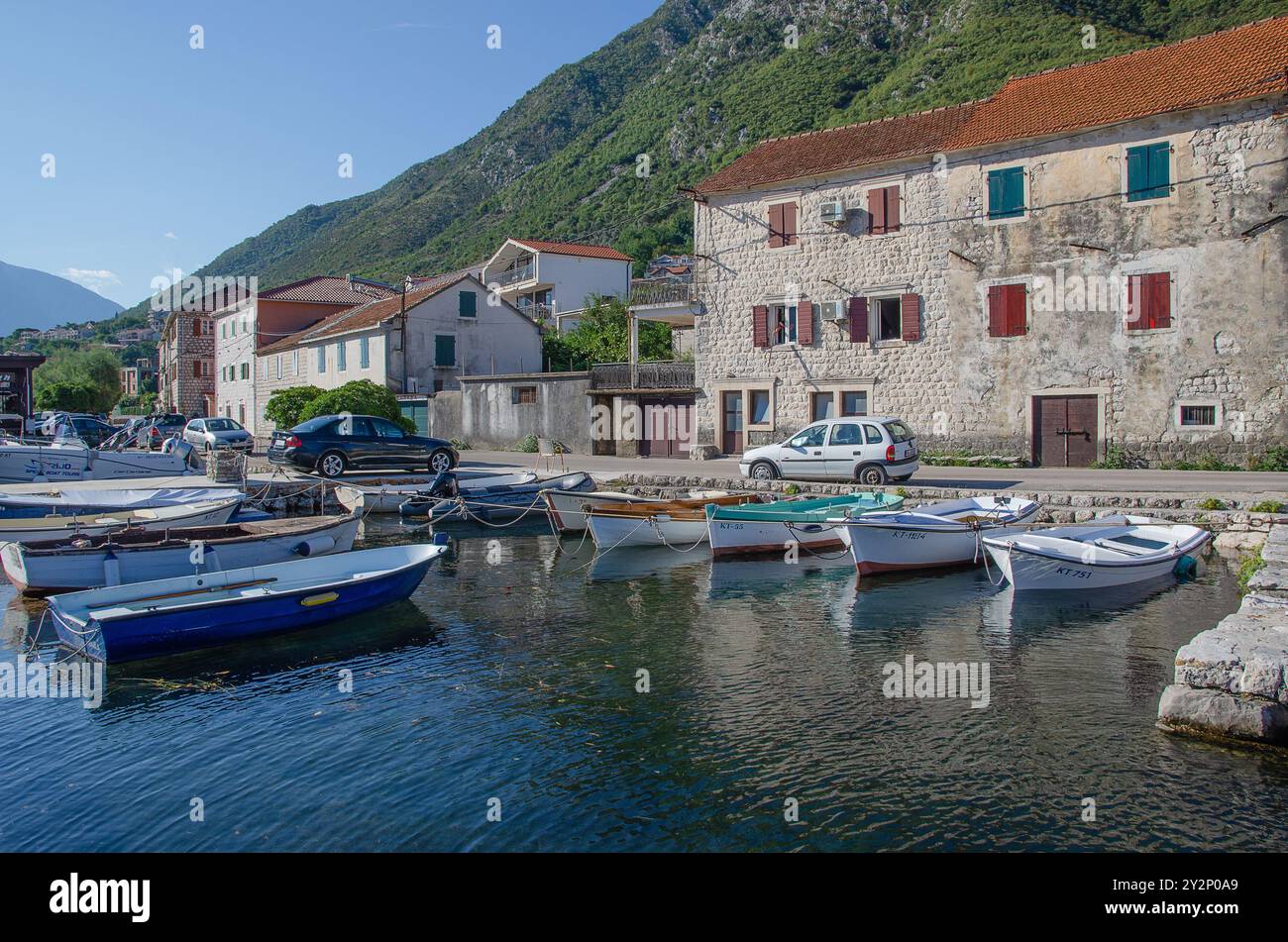 Prčanj village high street with small harbour, moorings and traditional ...