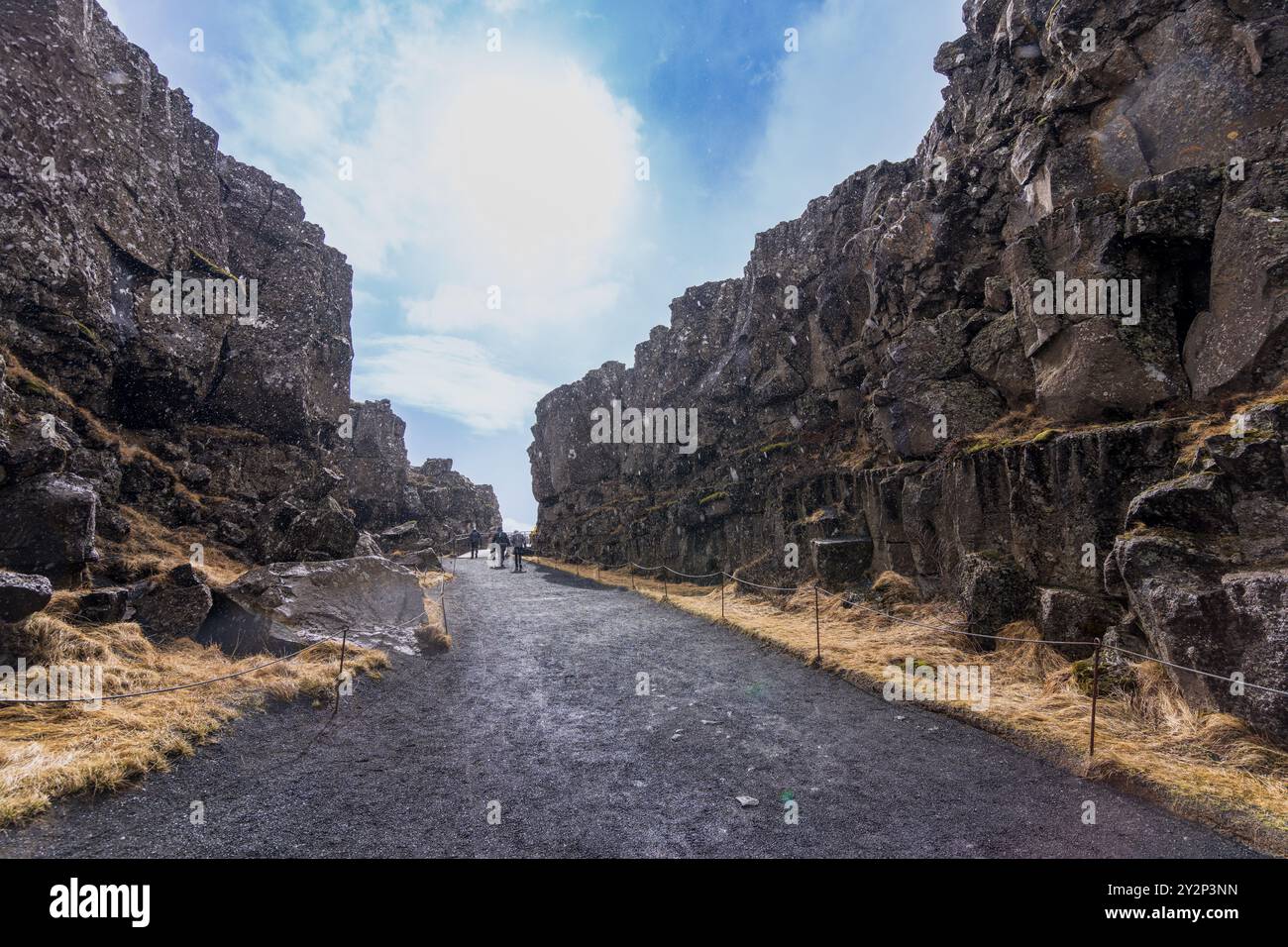 A hiker walks along a trail in Thingvellir National Park, Iceland, with ...