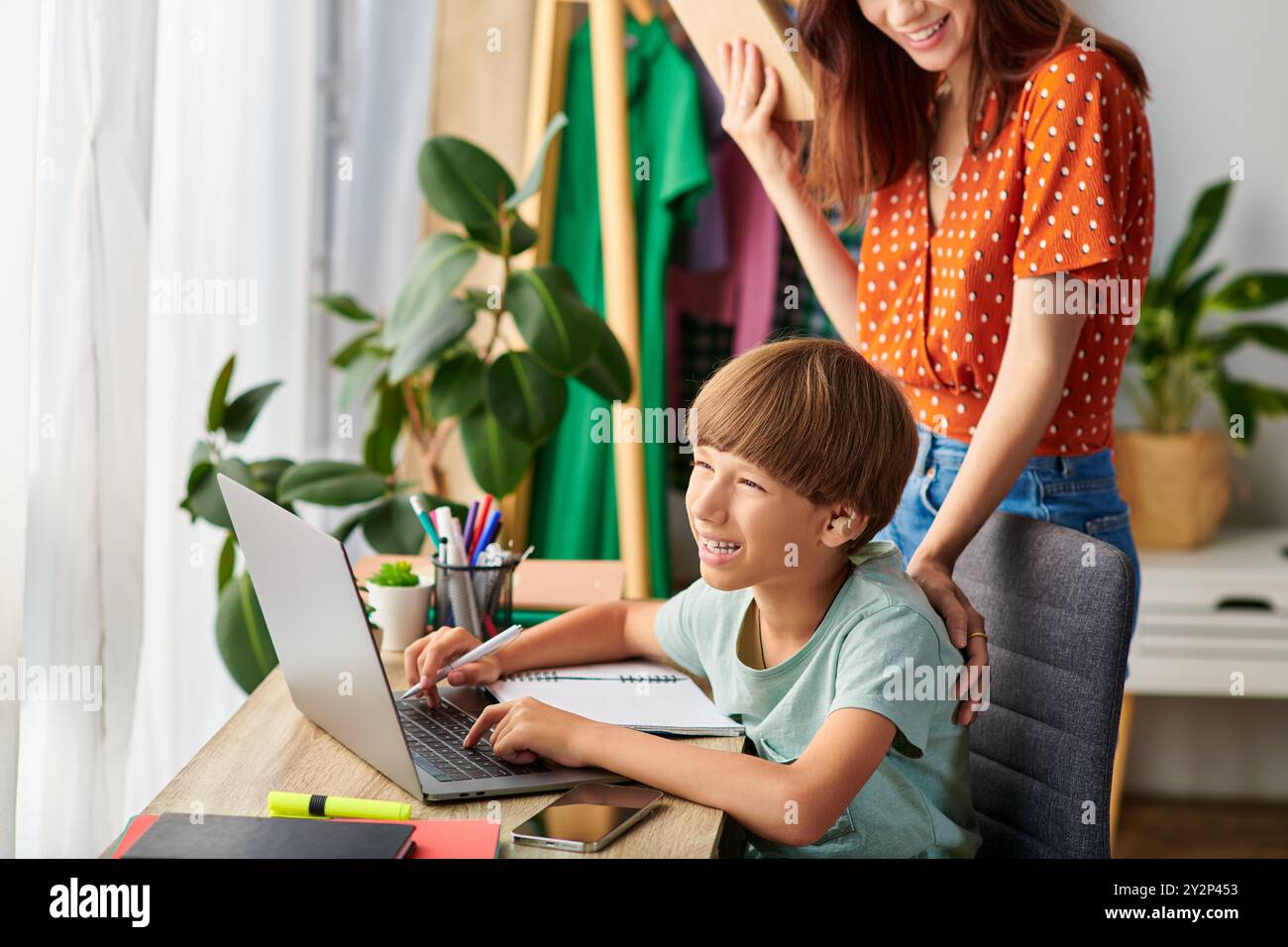 A mother shares laughter with her son as they engage in learning ...