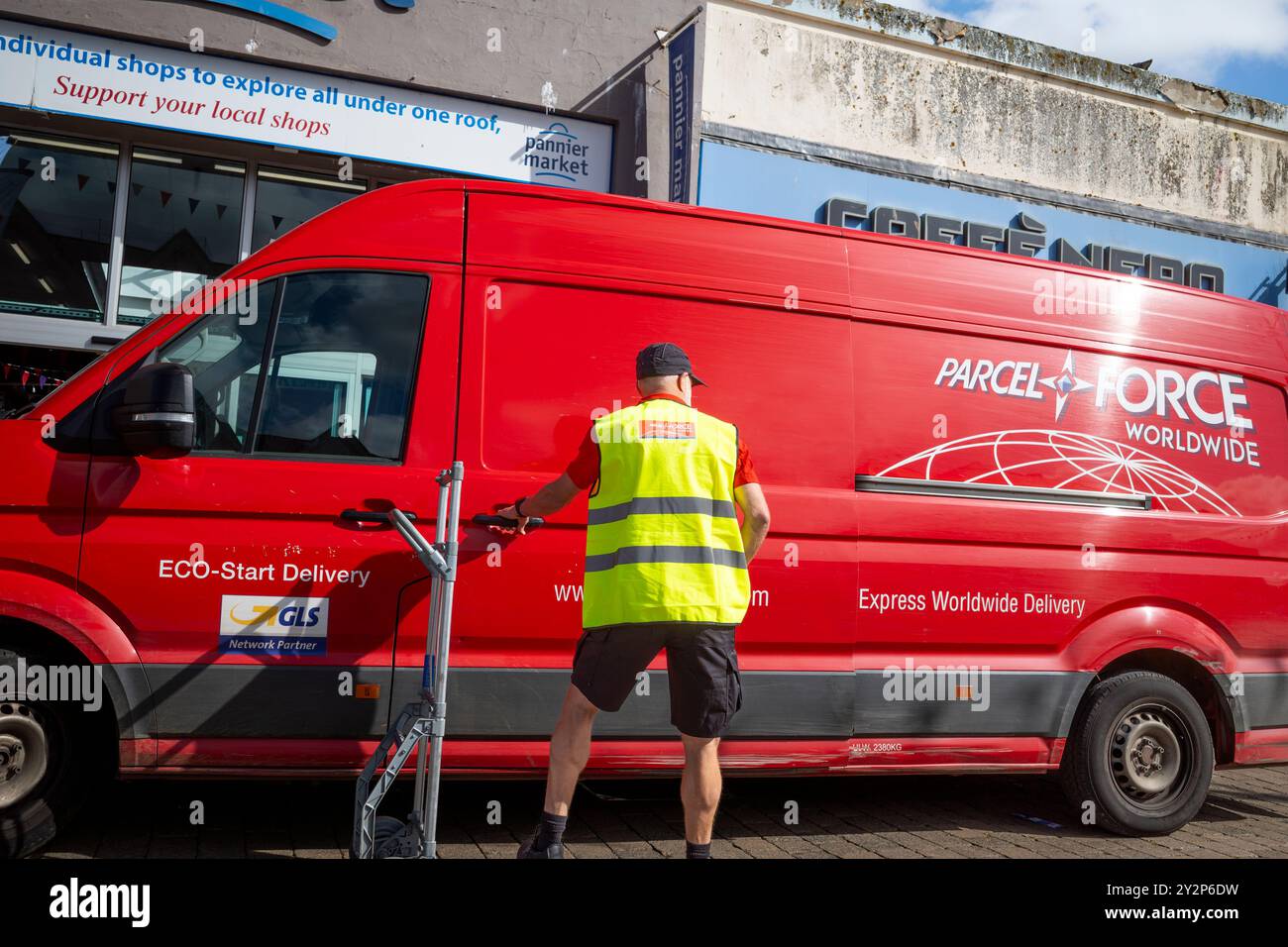A Parcelforce worker opening the side door of his van truck In Truro ...