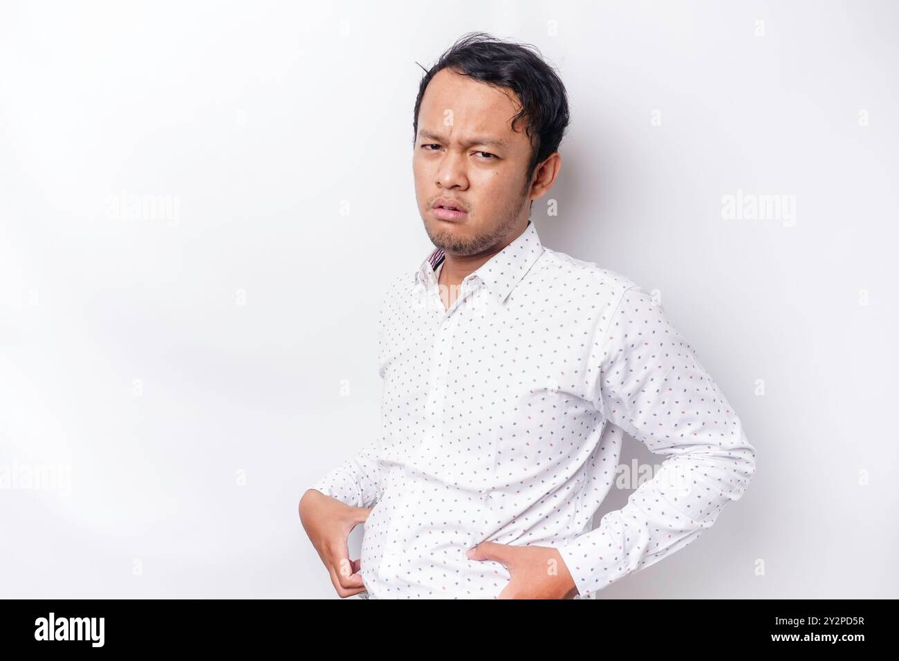 A portrait of insecure Asian fat man is holding the fat on his belly ...