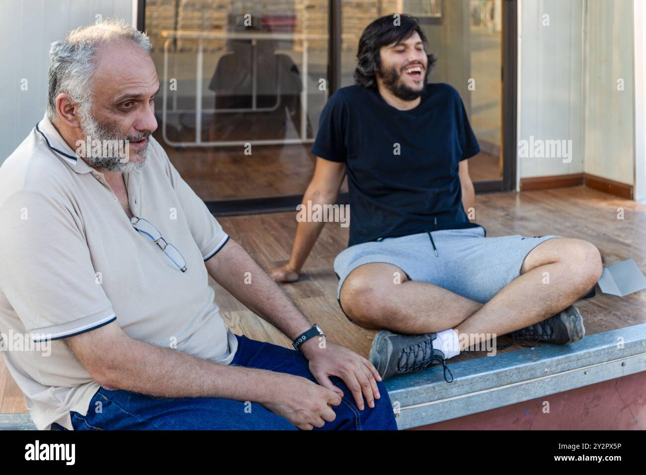 old man with a young friend in front of a portable cabin in a trailer ...