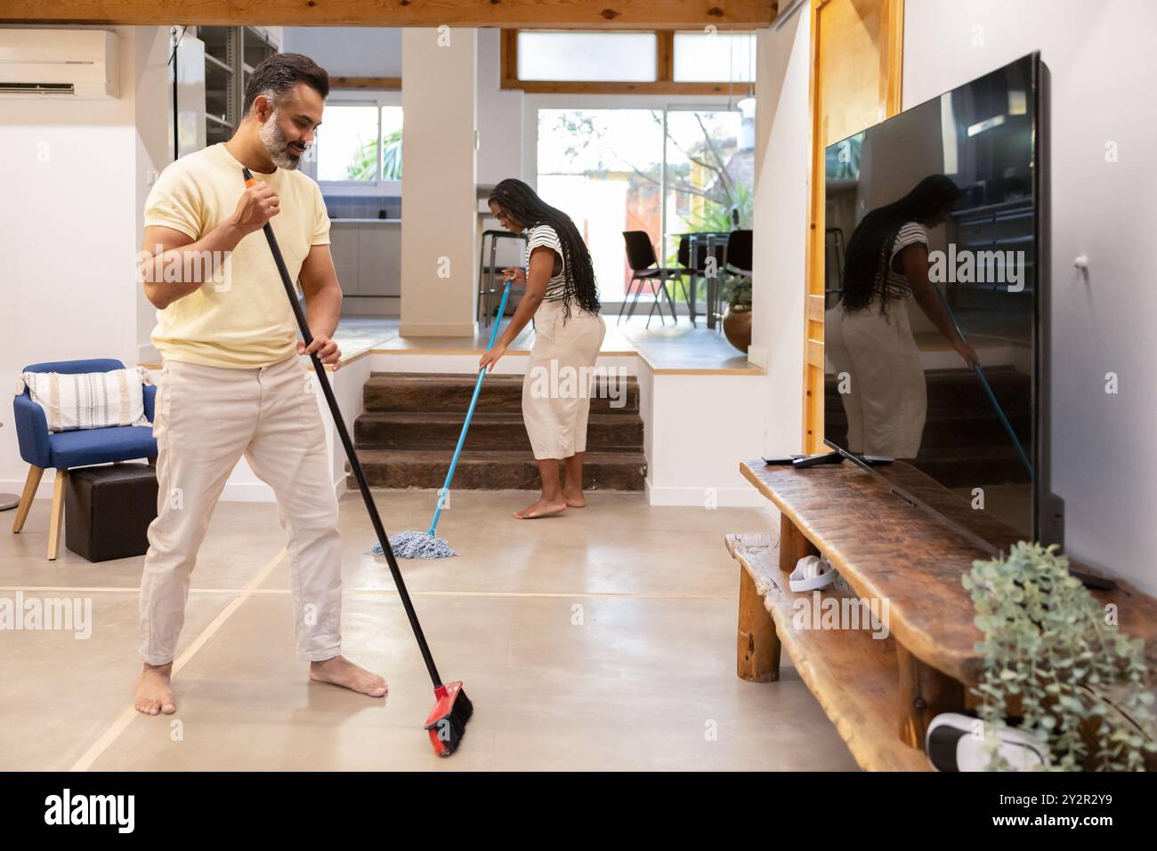 An indian man and a black woman work together to clean a spacious ...