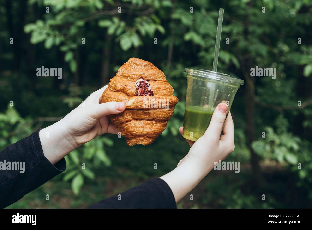 Cropped unrecognizable teenager girl enjoying a scrumptious croissant ...