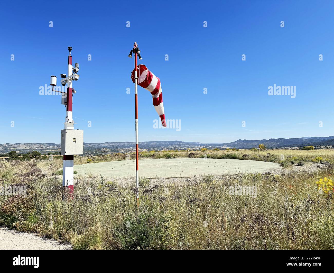 A remote emergency heliport set against a clear blue sky and expansive ...
