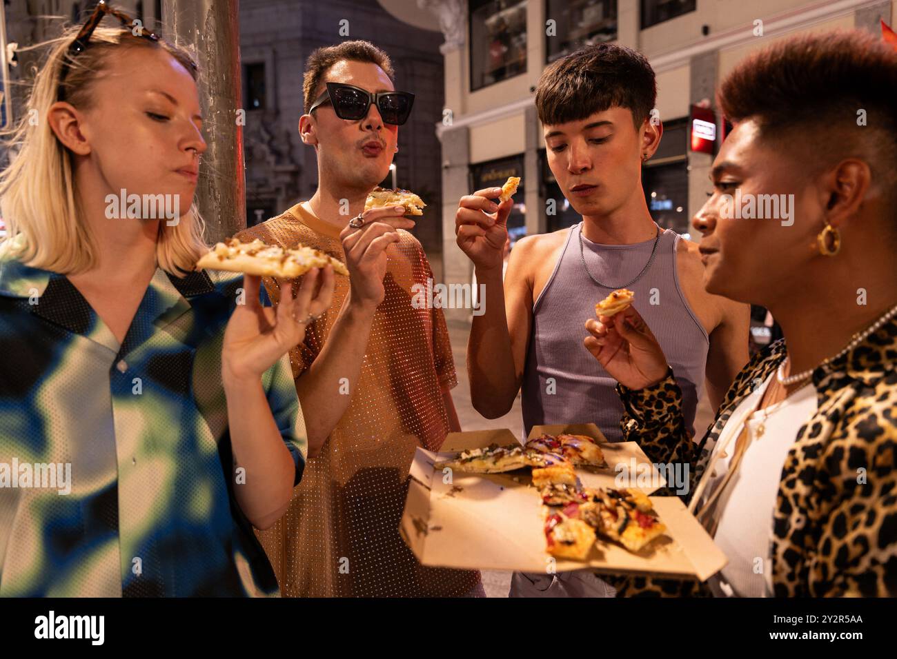 A vibrant group of LGBTQIA+ friends share slices of pizza on a lively ...