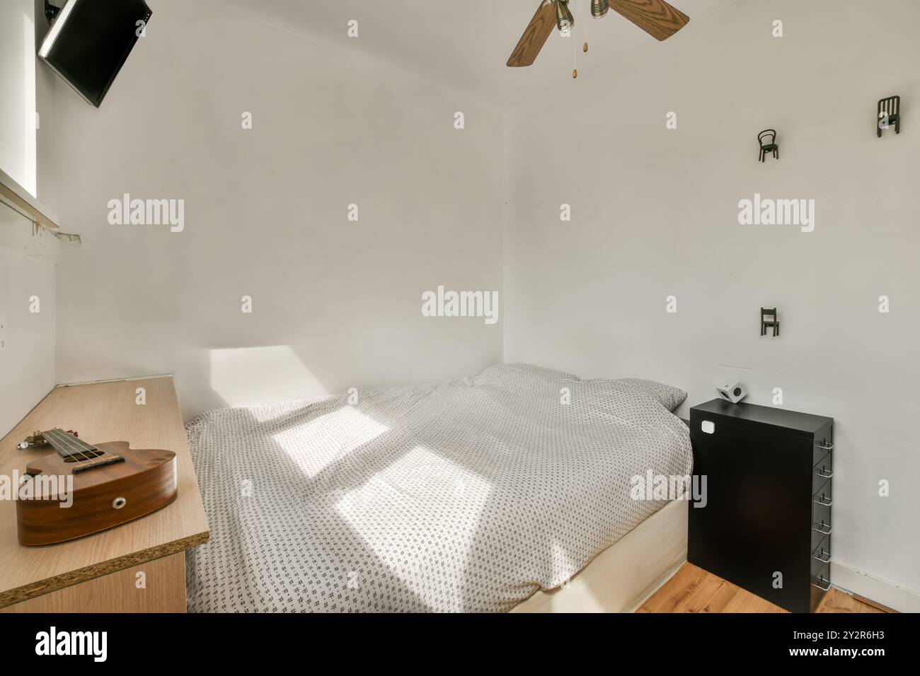 A well-lit, cozy small bedroom featuring a bed with polka dot sheets, a ...